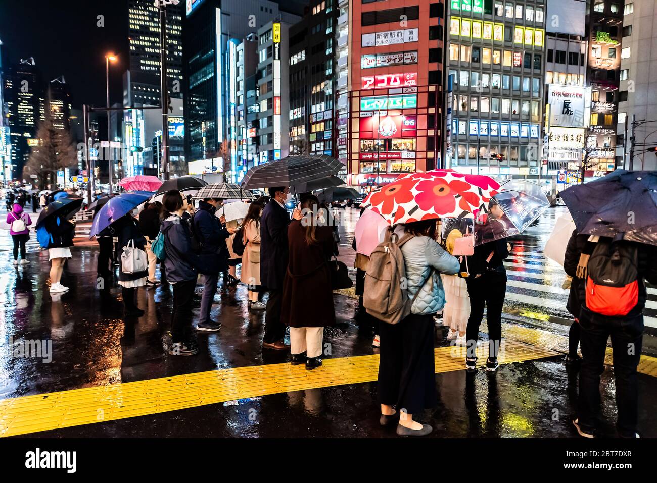 Shinjuku, Japan - 1. April 2019: Menschen mit Regenschirmen, die bei ...