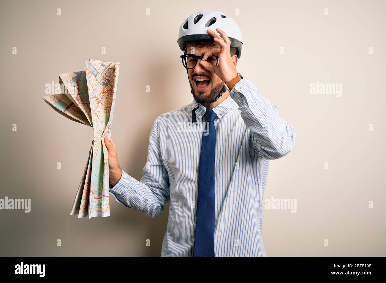 Junger Geschäftsmann trägt Brille und Fahrradhelm hält Stadtplan über ...