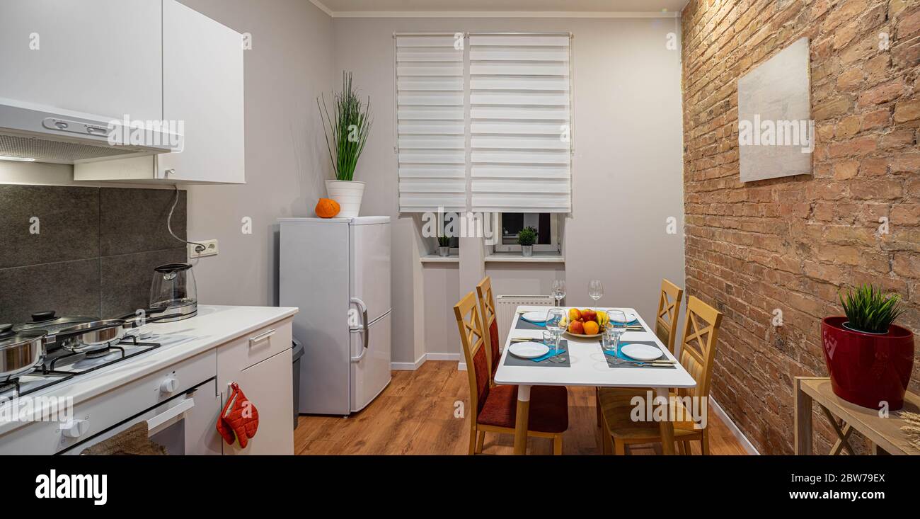 Moderne Loft-Interieur der Küche in der Wohnung. Ziegelwand. Tisch und ...