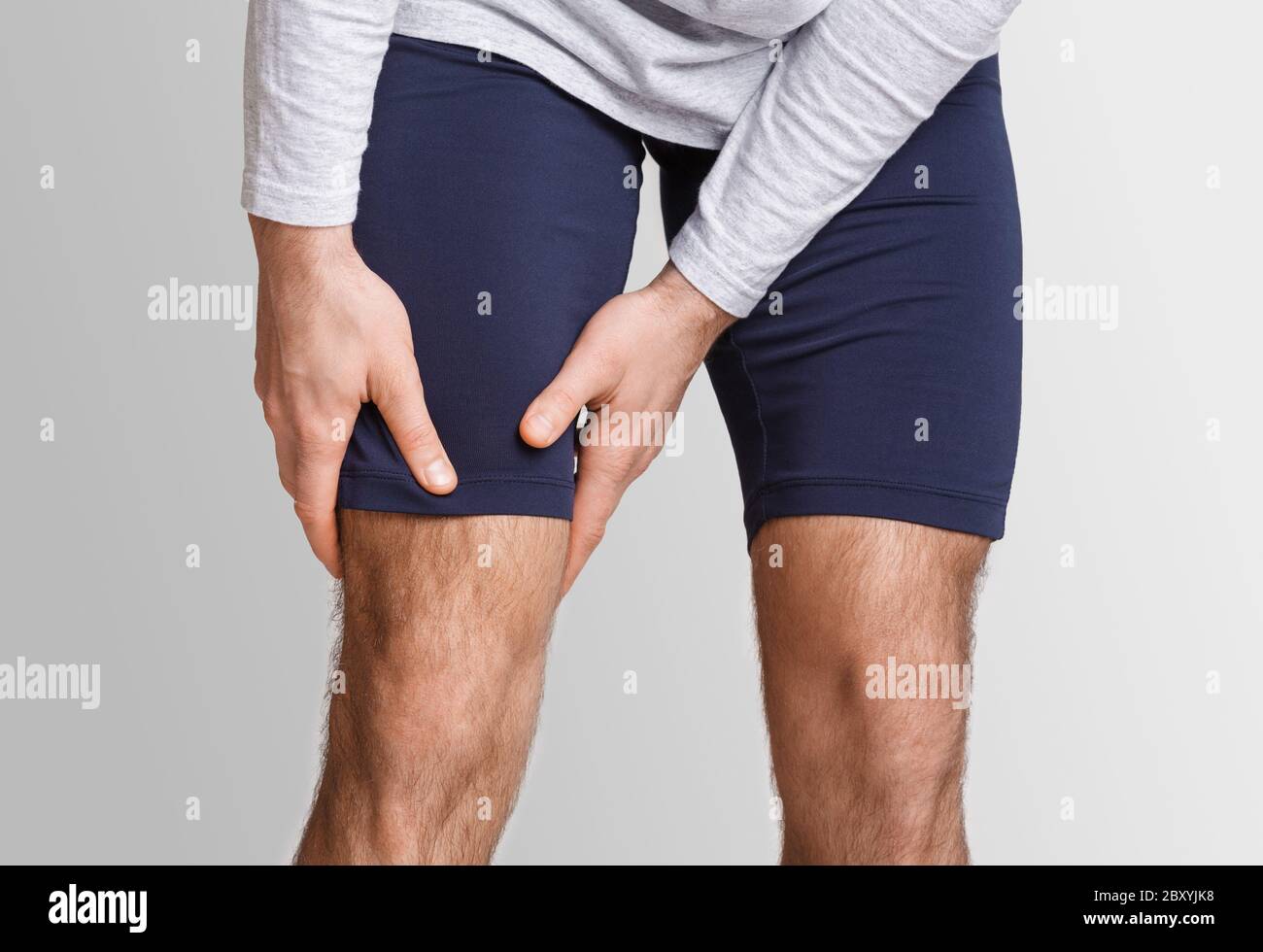 Muskelschmerzen bei Athleten. Der Mann in Sportbekleidung drückt die ...