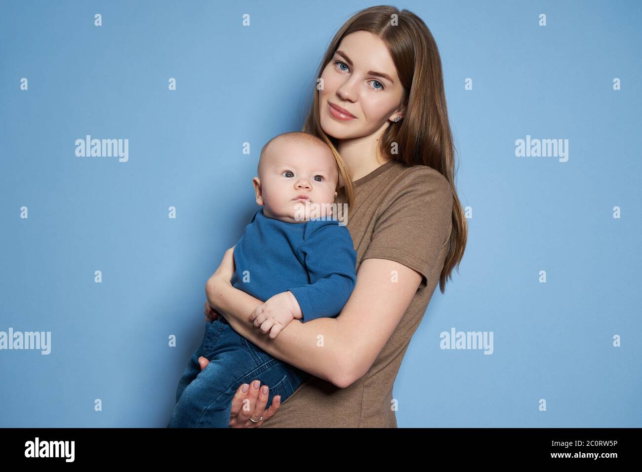 Die junge Mutter umarmt und küsst ihren kleinen Sohn. Eine Frau hält ein Kind in den Armen ...