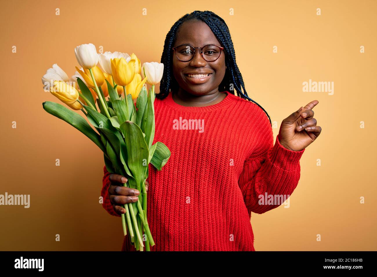 Junge afroamerikanische plus size Frau mit Zöpfen halten Bouquet von ...