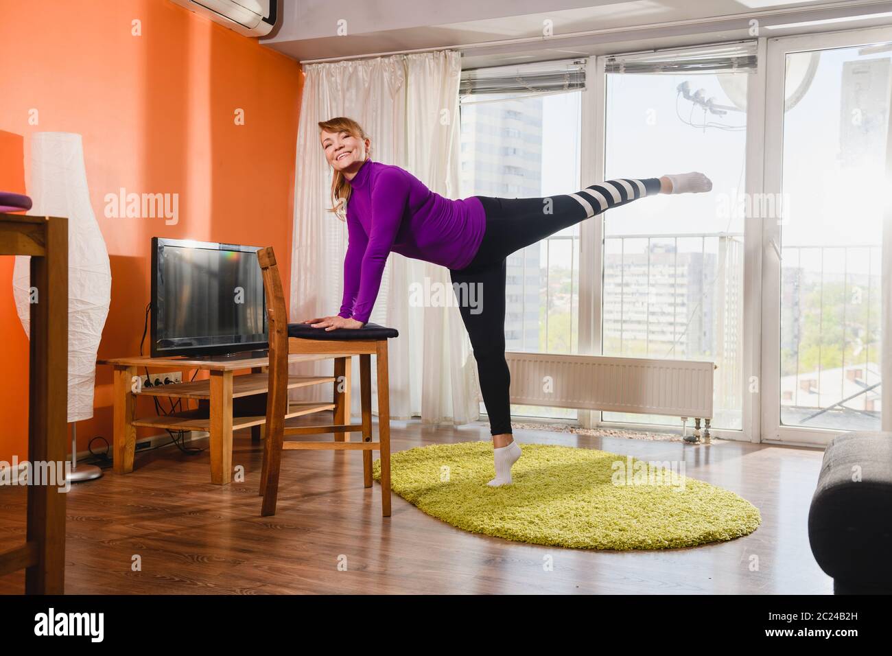 Ältere lächelnde Frau Workout-Übung Stretching im Inneren, legte die ...