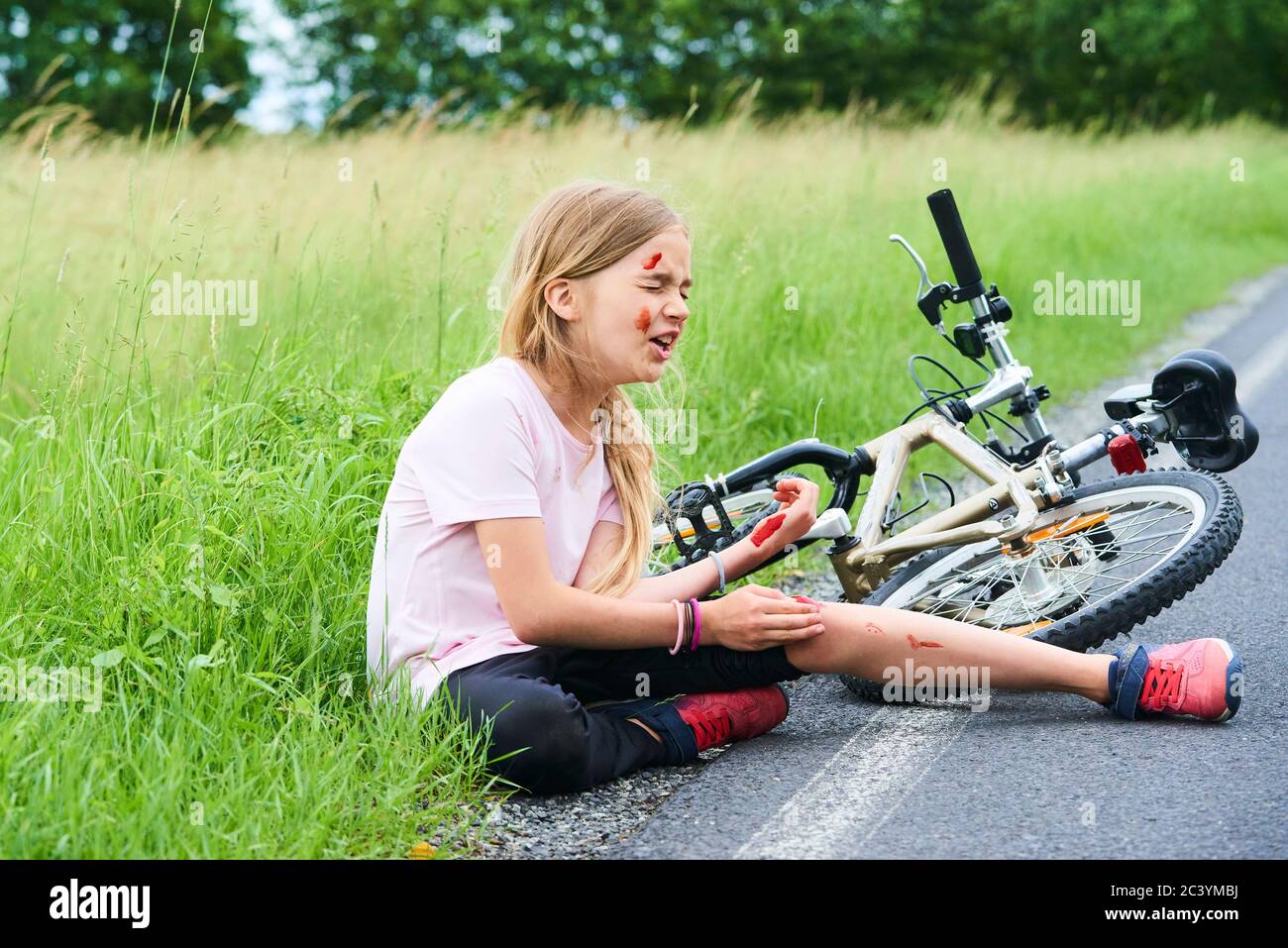 Trauriger weinender kleiner Kindermädchen fiel vom Fahrrad im ...