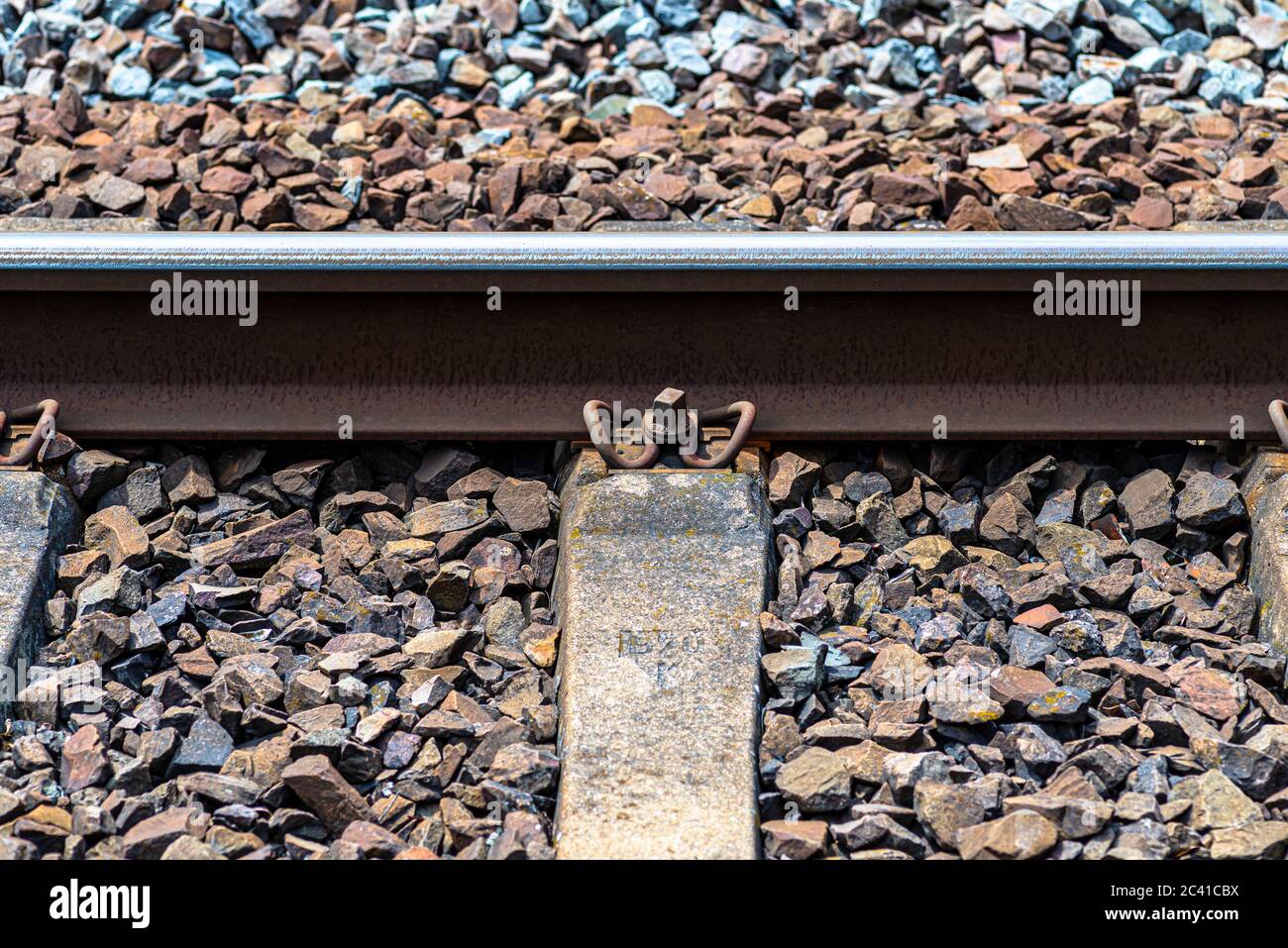 Eisenbahnschienen auf Betonschwellen liegend, zwischen großen ...