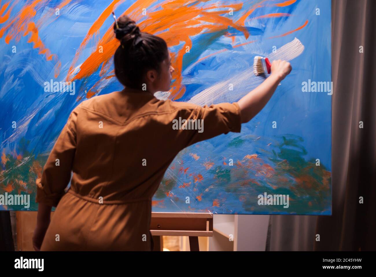 Frau entspannende Malerei in Kunststudio auf große Leinwand. Moderne Kunst malen auf Leinwand ...