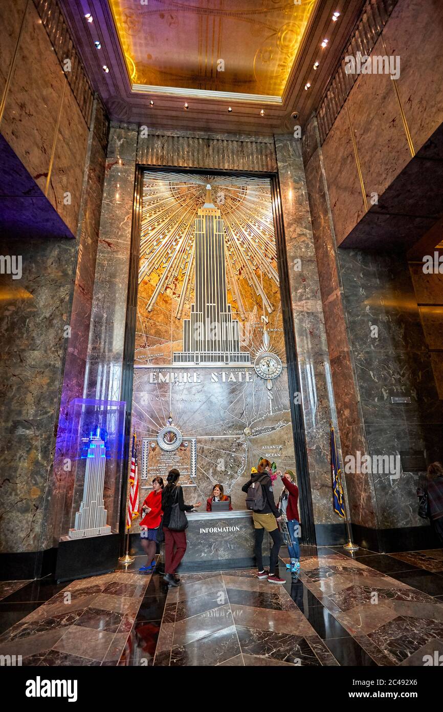 Die Leute warten am Informationsschalter in der Lobby des Empire State ...
