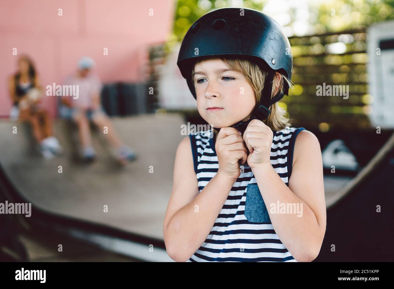 Skateboarder Junge in Helm posiert im Skate Park. Kid Boy mit ...