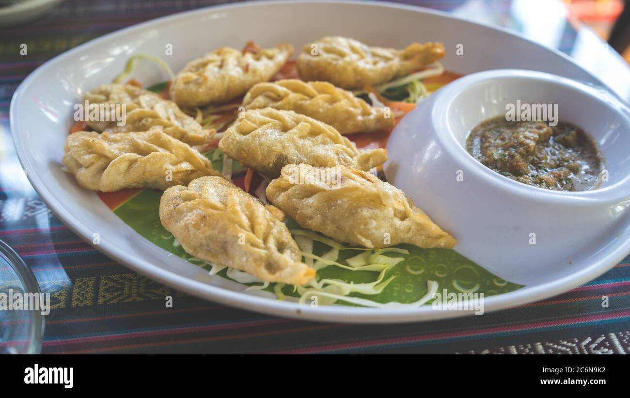 Ein Gericht des tibetisch gebratenen momo mit einer Sauce. Momo ist ein ...