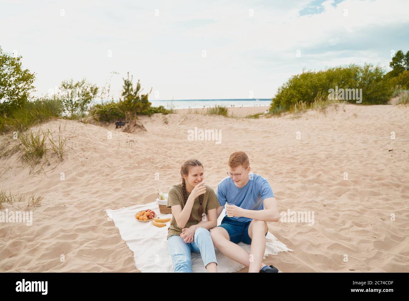 Picknick am Strand mit Essen und Getränken. Junge junge und Mädchen auf ...