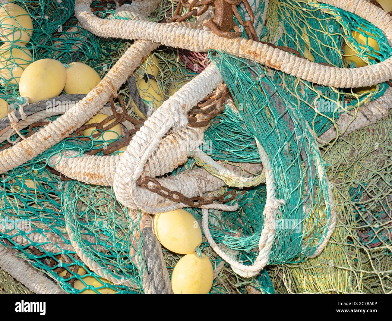 Das Fischernetz trocknet im Hafen. Grünes Netz, gelbe Bojen und rostige ...