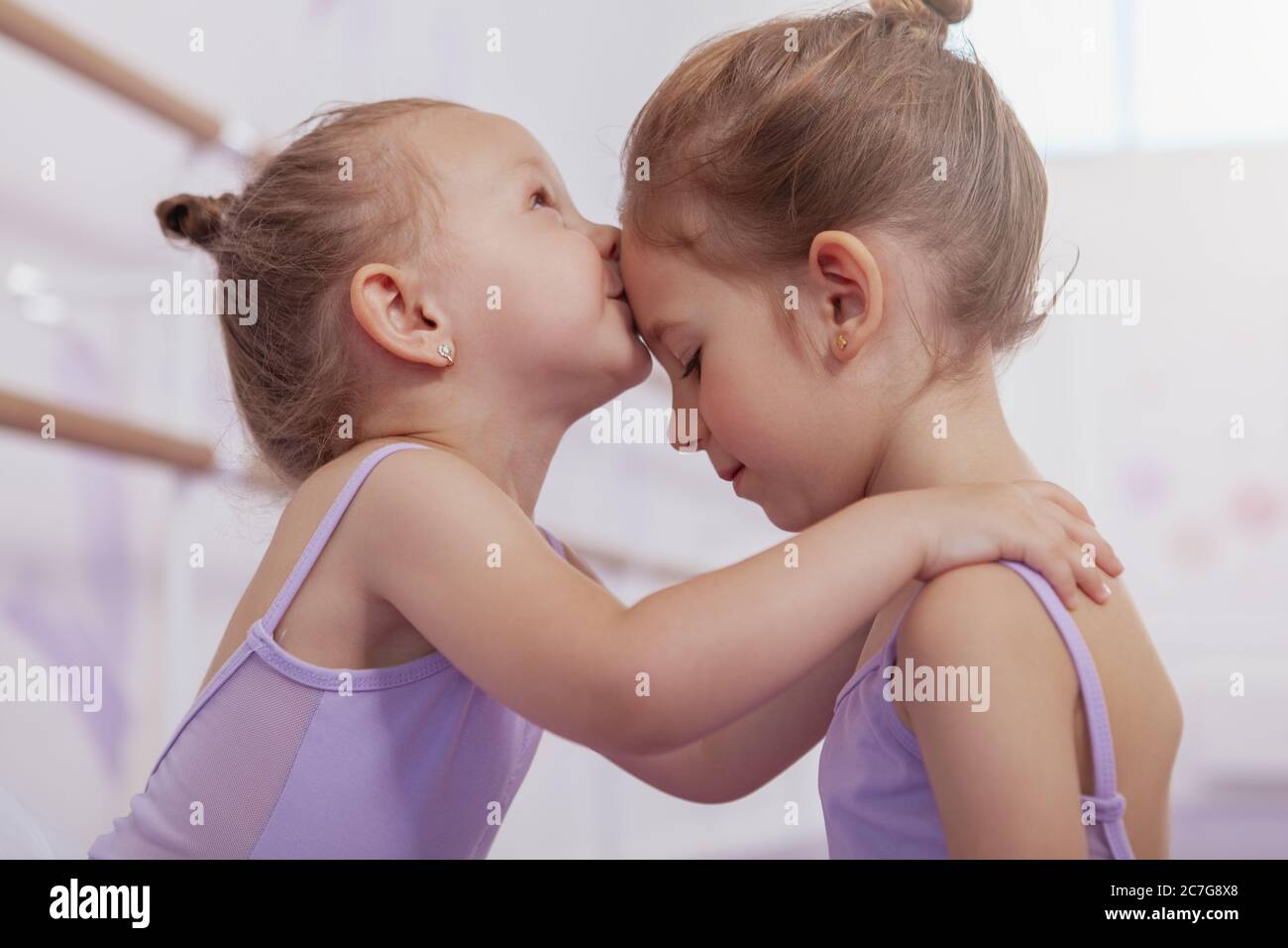 Two kissing cute little sisters -Fotos und -Bildmaterial in hoher Auflösung – Alamy