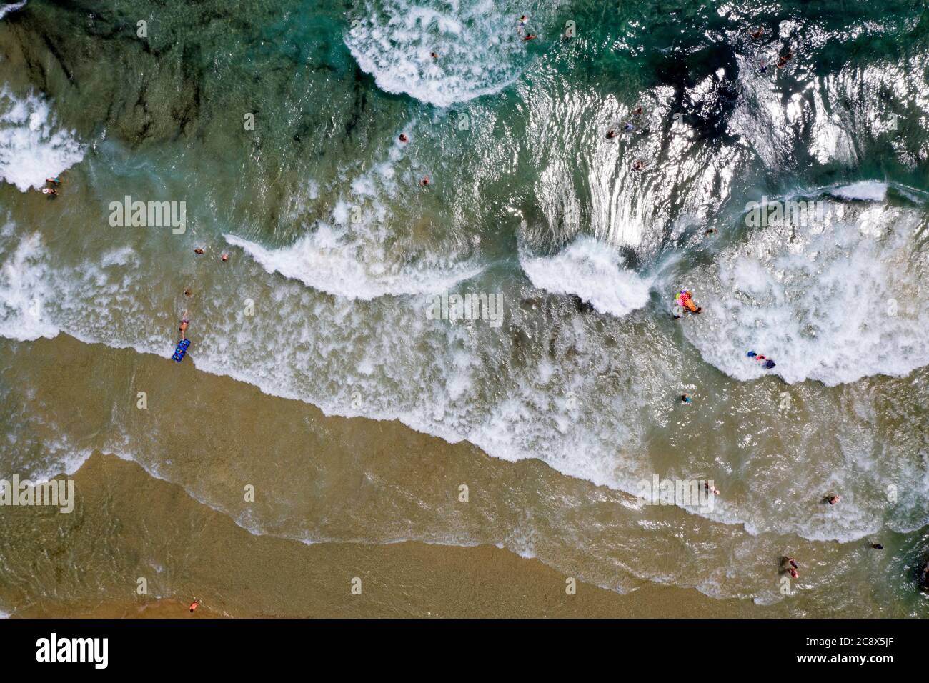 Luftaufnahme des Sandstrandes mit schwimmenden Menschen in der ...