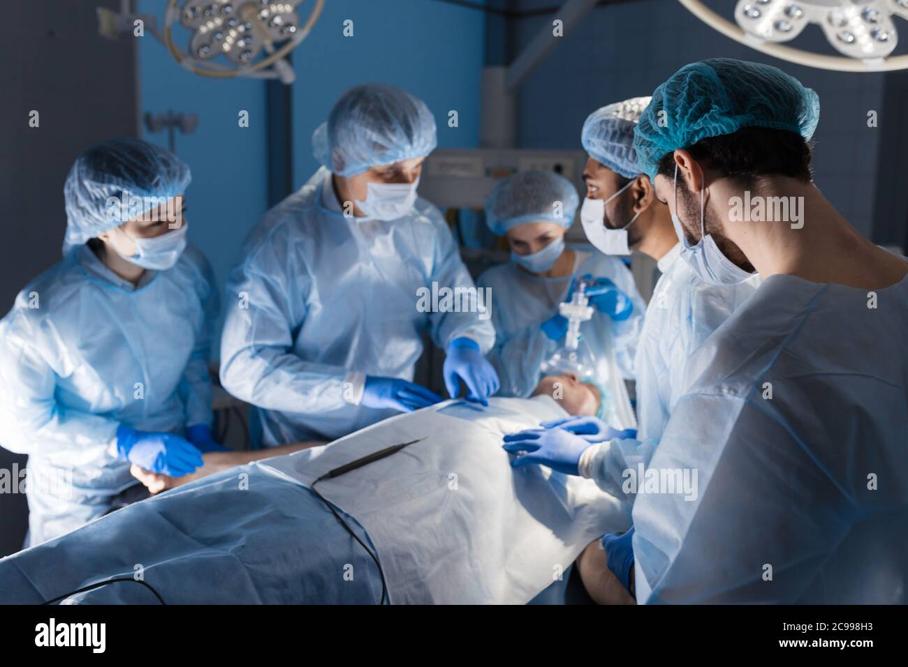 Team-Arbeit von Chirurgen, die Chirurgie an einem Patienten unter ...