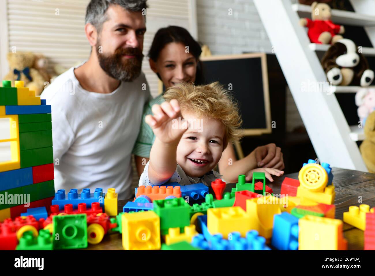 Junge Familie verbringt Zeit im Spielzimmer. Eltern beobachten Sohn mit ...