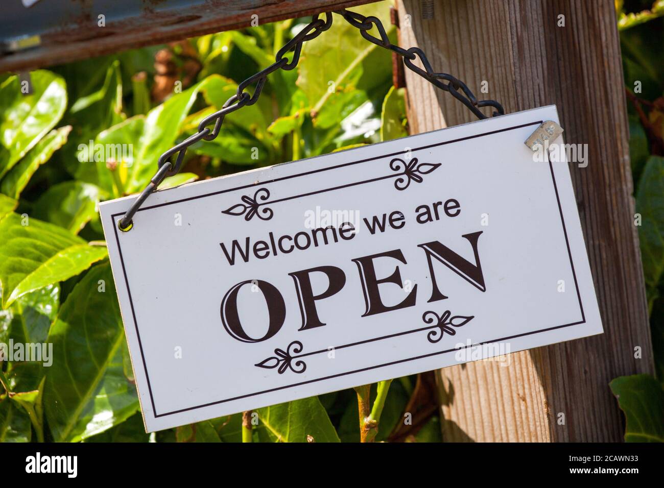 Wir sind offen Schild hängen auf bewaldeten Pfosten Stockfotografie - Alamy