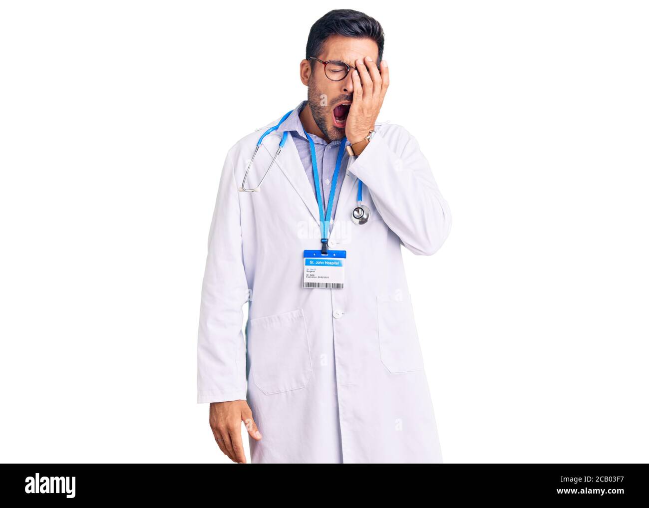 Junge hispanic Mann trägt Arzt Uniform und Stethoskop gähnend müde ...