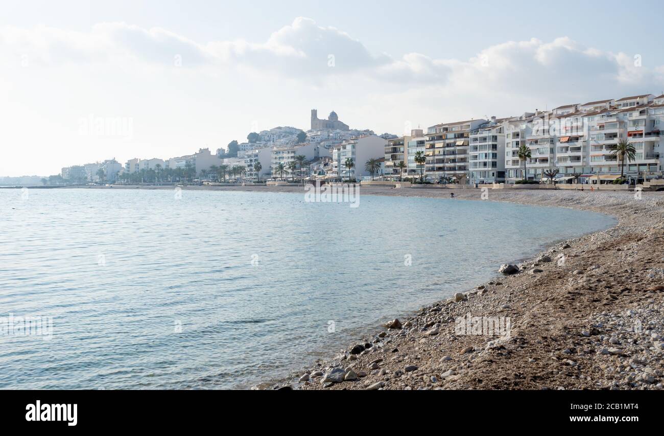 Steinstrand mit Blick auf die sonnige Altea Stadtküste mit Hügel und ...