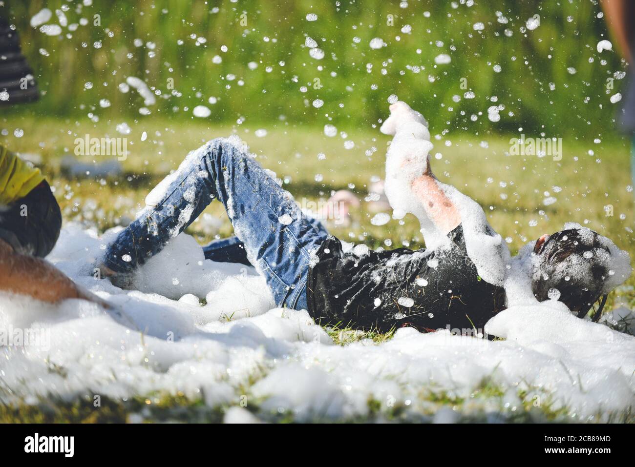 Junge Leute im Schaum. Eine Schaumparty. Gruppe von Kindern, die Spaß ...
