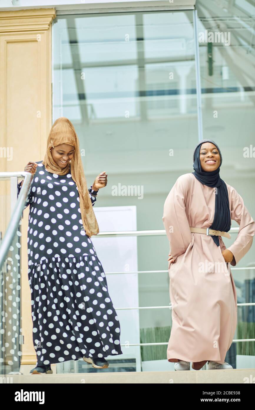 Ein paar muslimische afrikanische 20 er Freundinnen mit Hijab oder islamischen Kopfschlupfe und islamische traditionelle Kleidung mit SpaB Besuch modern Glasgeschafte m Stockfotografie Alamy