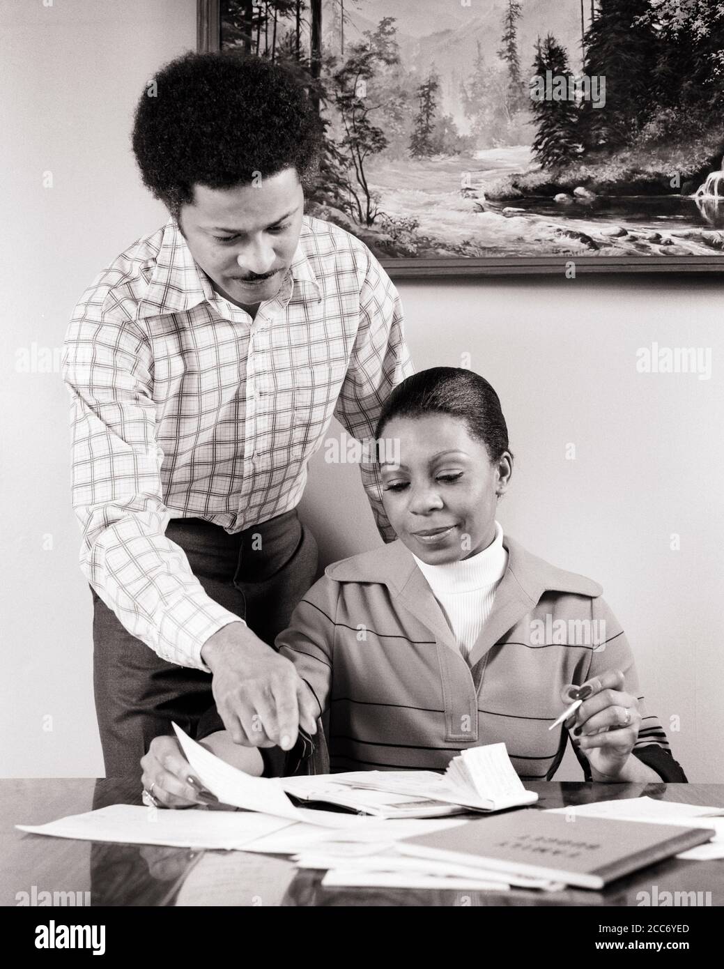 Sitzender mann am tisch mit stehender frau -Fotos und -Bildmaterial in ...