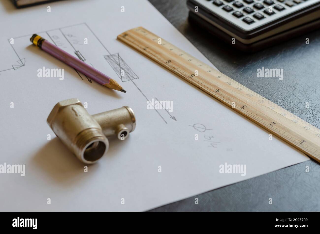 Blatt Papier mit einer Zeichnung der Hauswasserversorgung auf dem Tisch ...