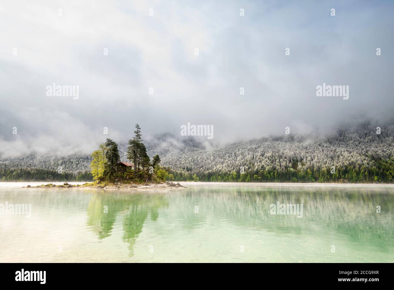 Eine kleine einsame Insel mit Blockhütte und rotem Dach, mitten im ...