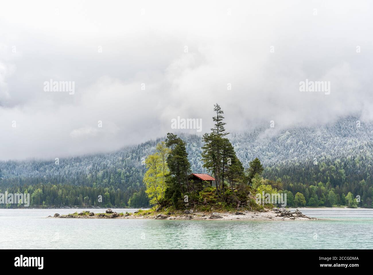 Eine kleine einsame Insel mit Blockhütte und rotem Dach, mitten im ...