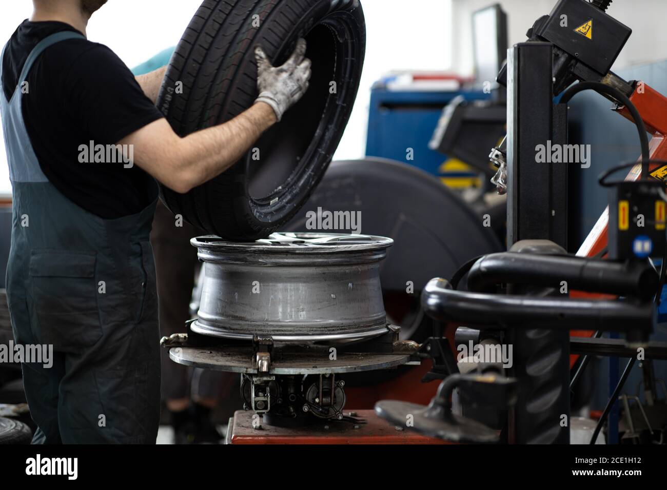 Der Automechaniker ändert die Reifen eines Autos in der Reparatur ...