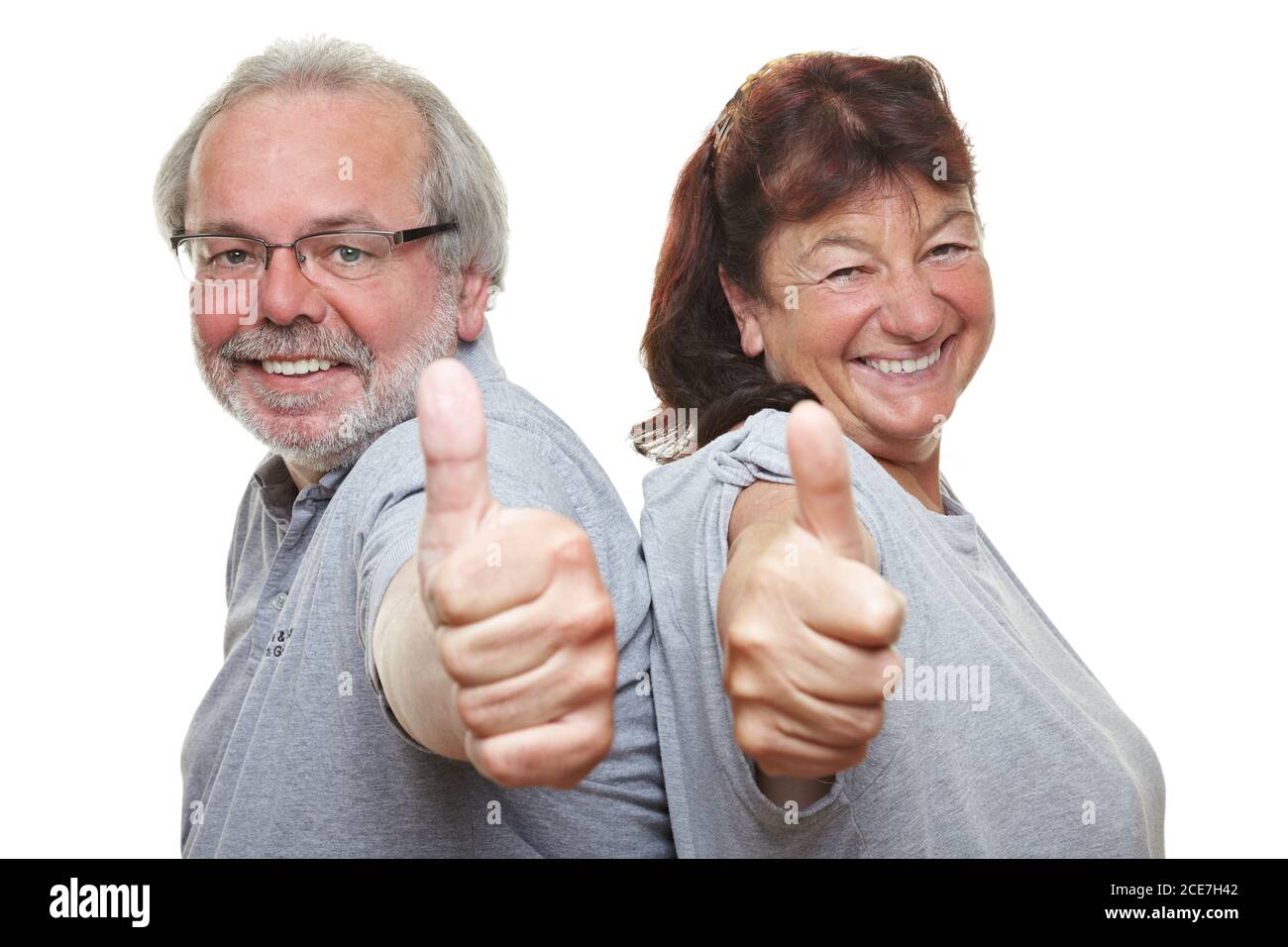 Zwei lachende, zufriedene Rentner halten den Daumen hoch ...