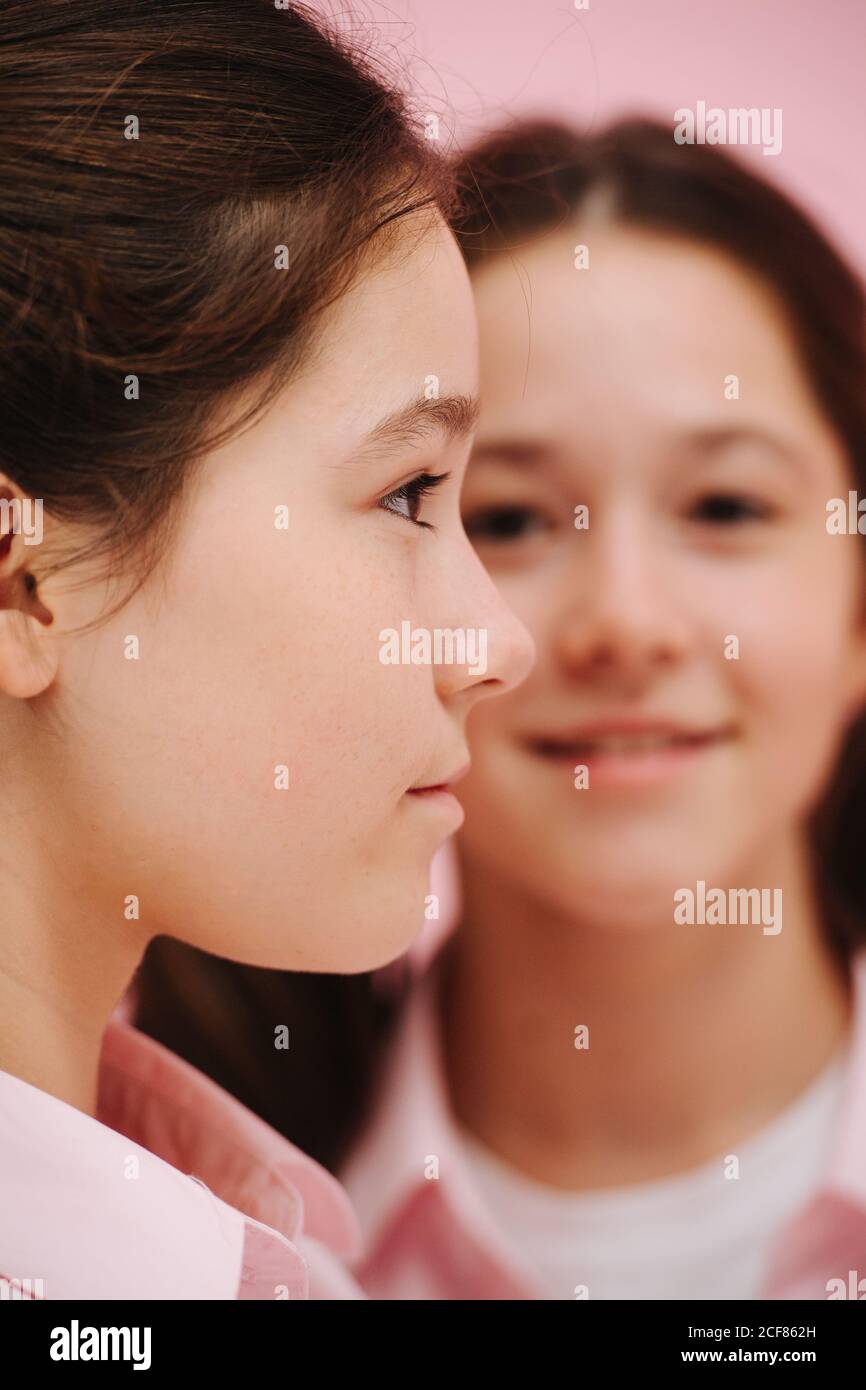 Hübsche kleine Zwillingsschwestern posieren. Eine zeigt die andere ...