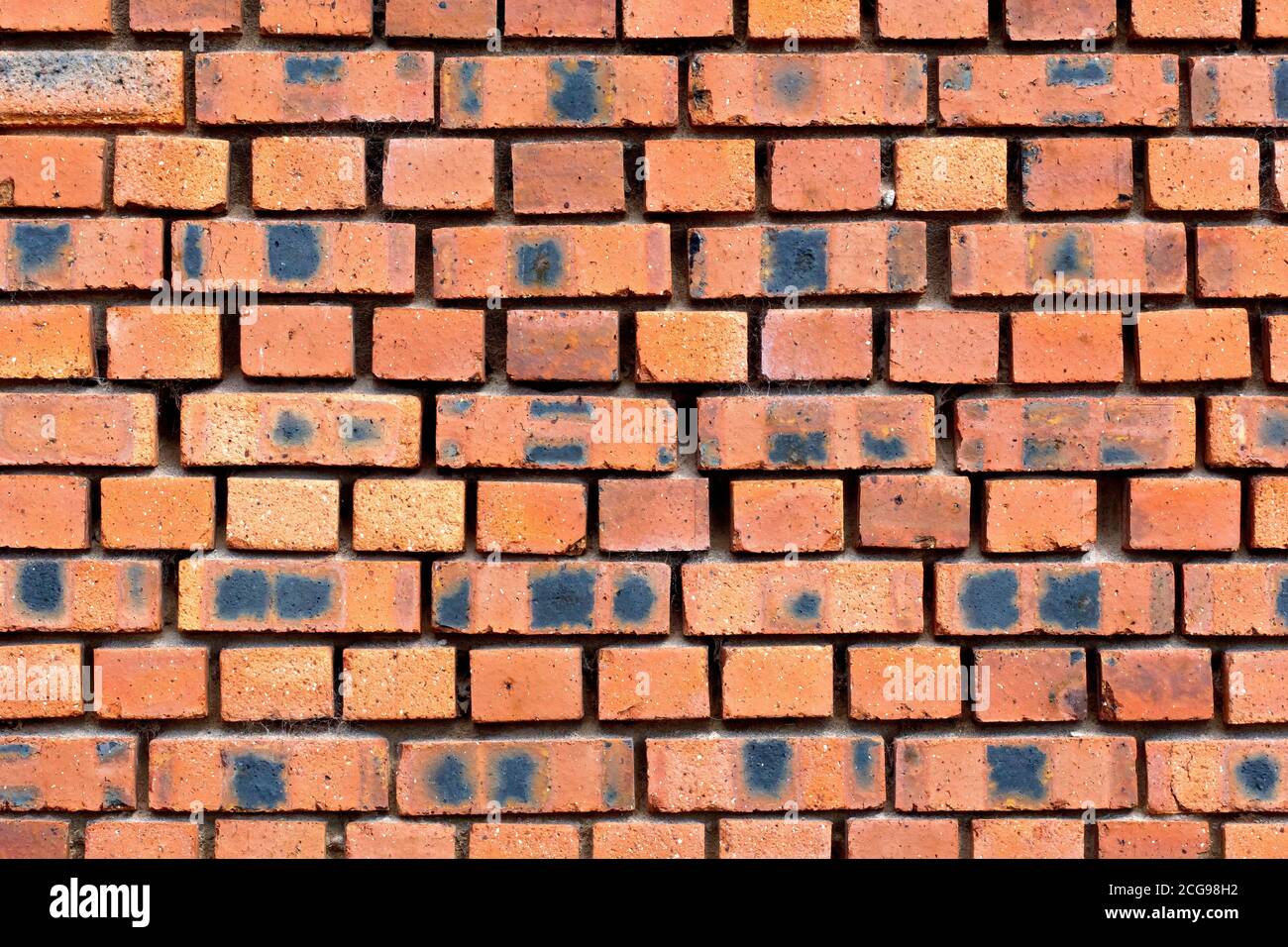 Eine Aufnahme einer roten Ziegelwand, die das regelmäßige lineare ...