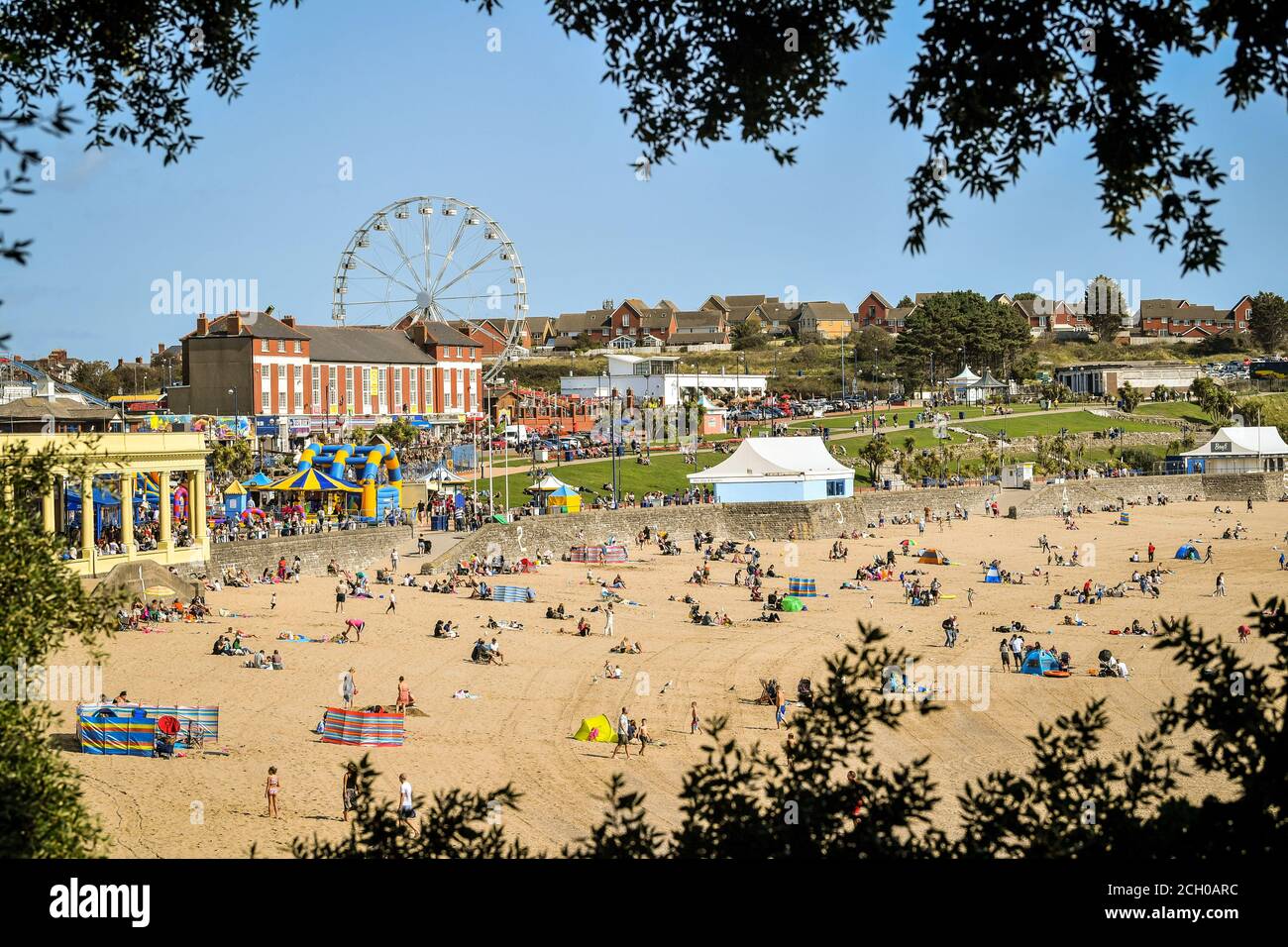 Menschen am Strand von Barry Island, Wales, genießen die Herbstsonne ...