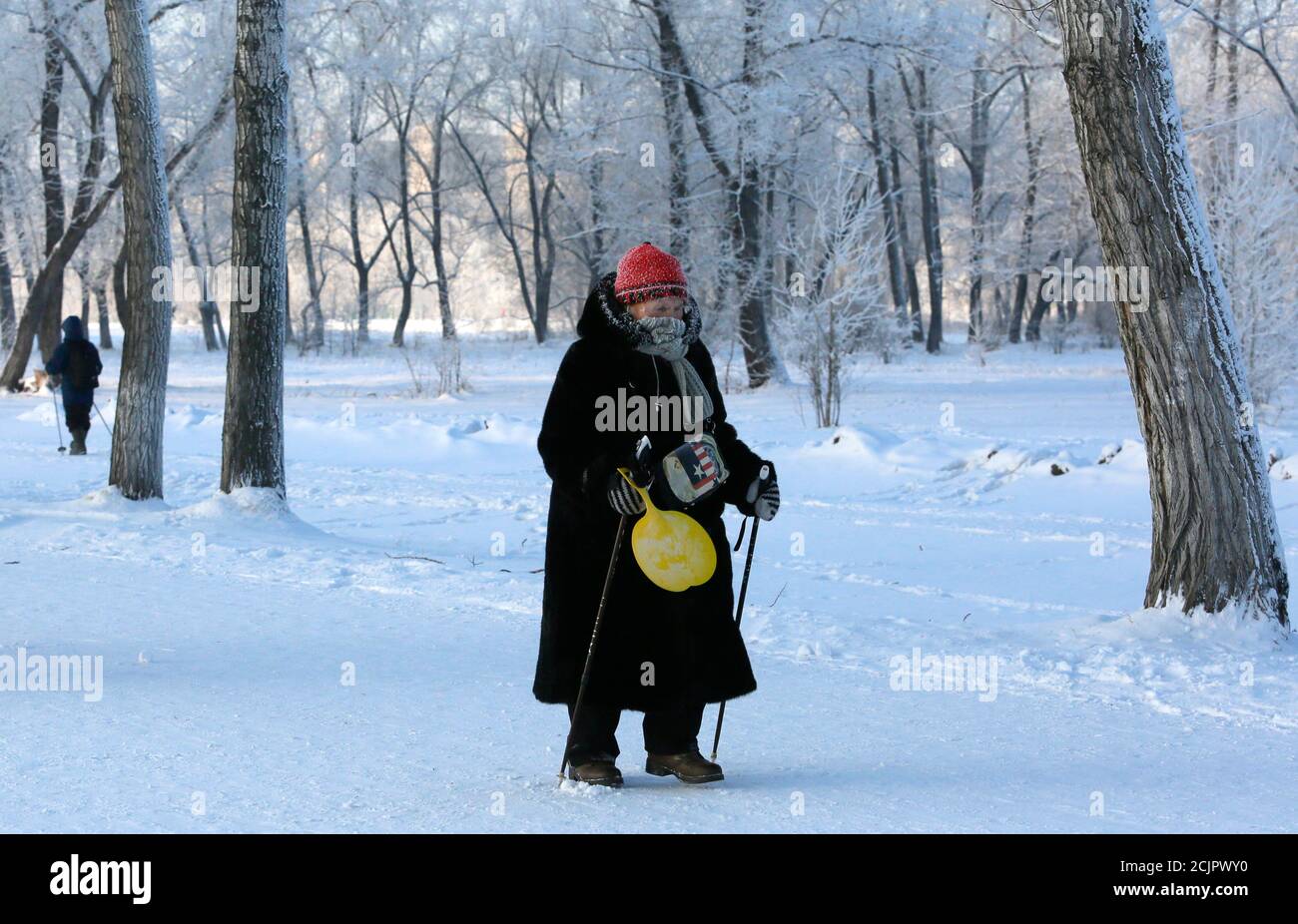 Eine Frau geht in einem Park bei der Lufttemperatur von etwa minus 24 ...