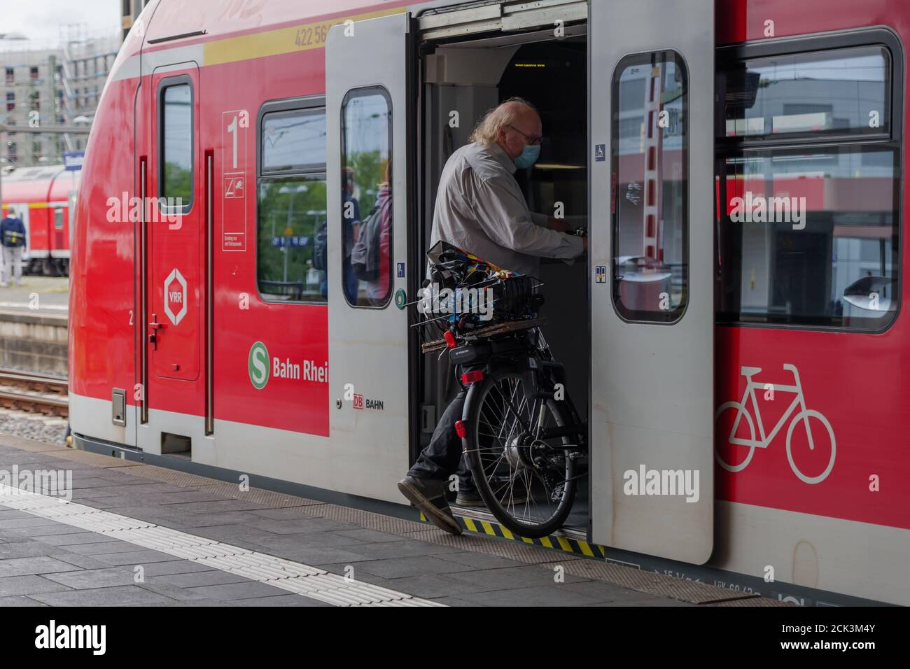 Alter männlicher Fahrgast mit seinem Fahrrad steigen in den S-Bahn Zug ...