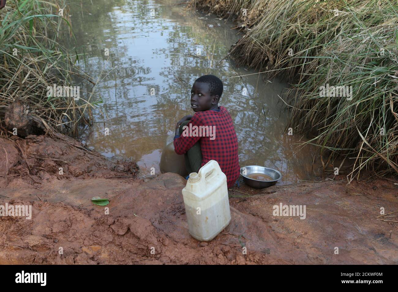 Ein Kind, die Kämpfe im Südsudan geflohen sammelt Wasser aus einem Tal ...