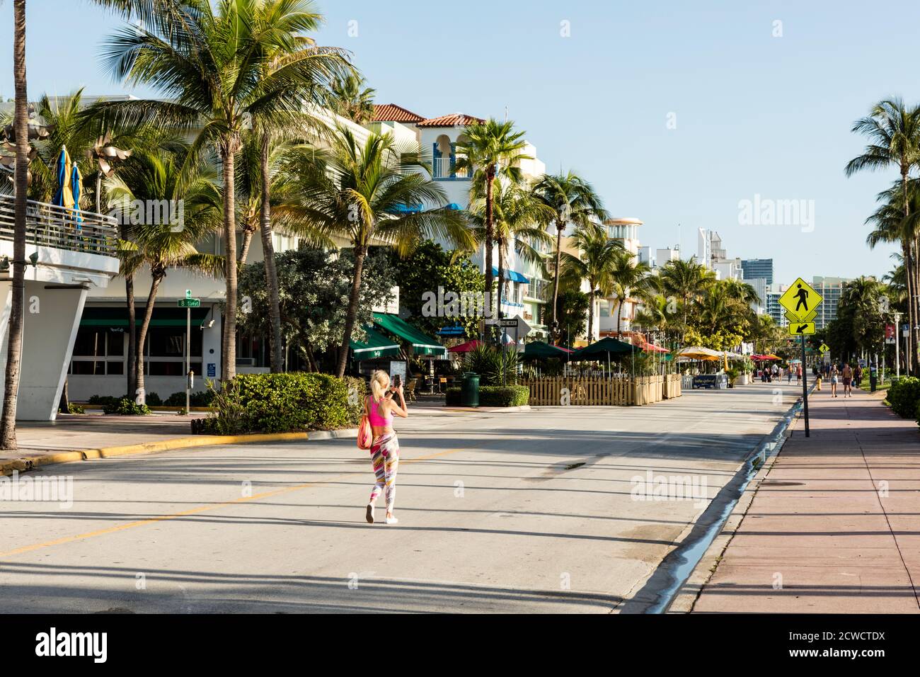 Eine Frau, die auf dem Ocean Drive ohne Autos ein Foto macht, in Miami ...