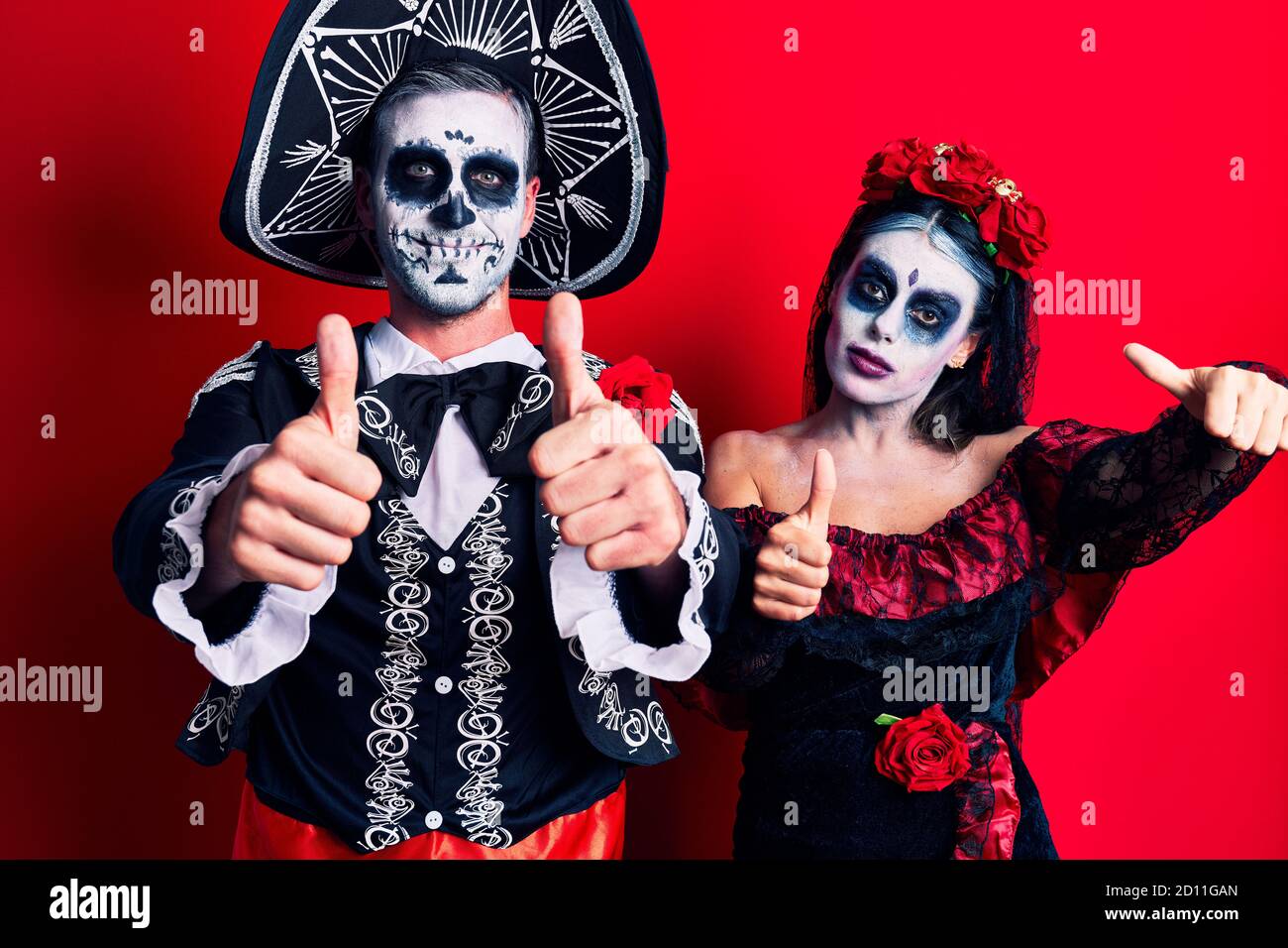 Junges Paar trägt mexikanische Tag der Toten Kostüm über rot ...
