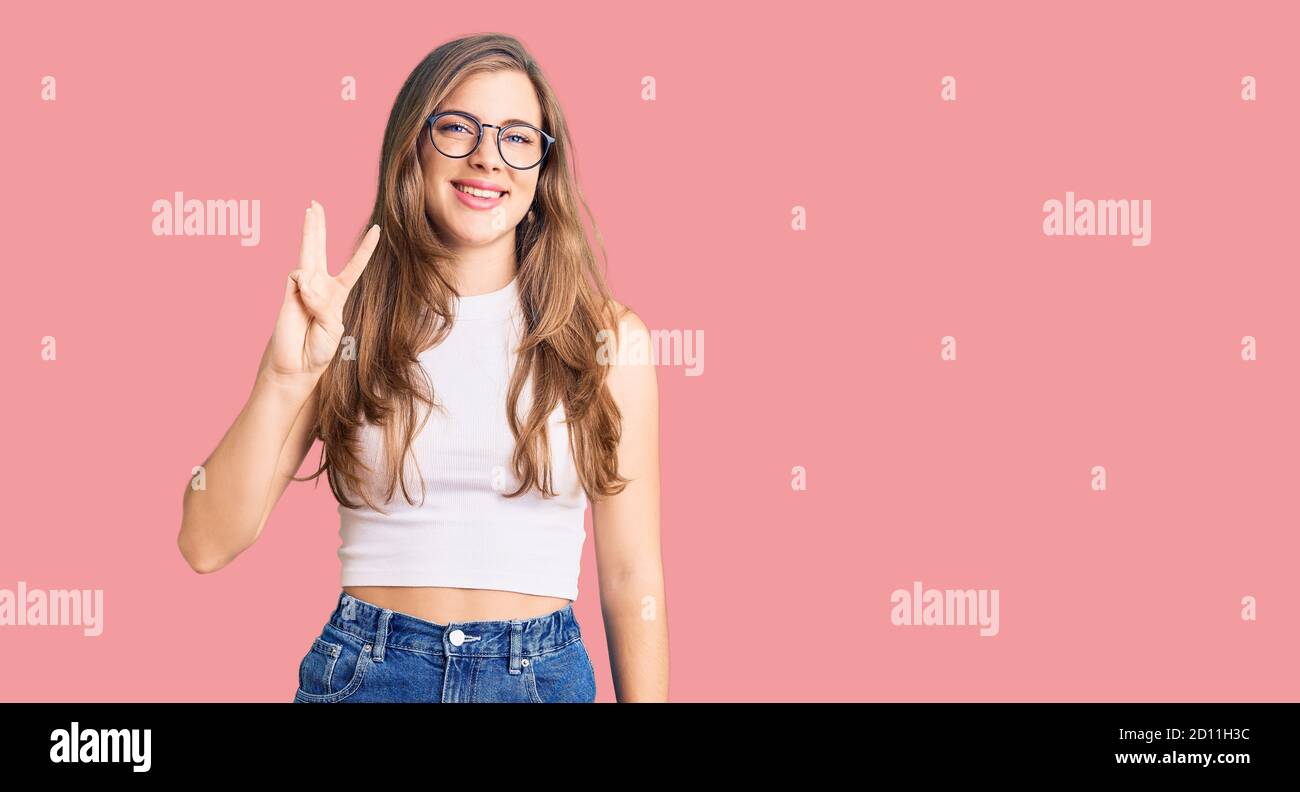 Schöne kaukasische junge Frau trägt Freizeitkleidung und Brille zeigt ... Schöne kaukasische junge Frau trägt Freizeitkleidung und Brille zeigt ...