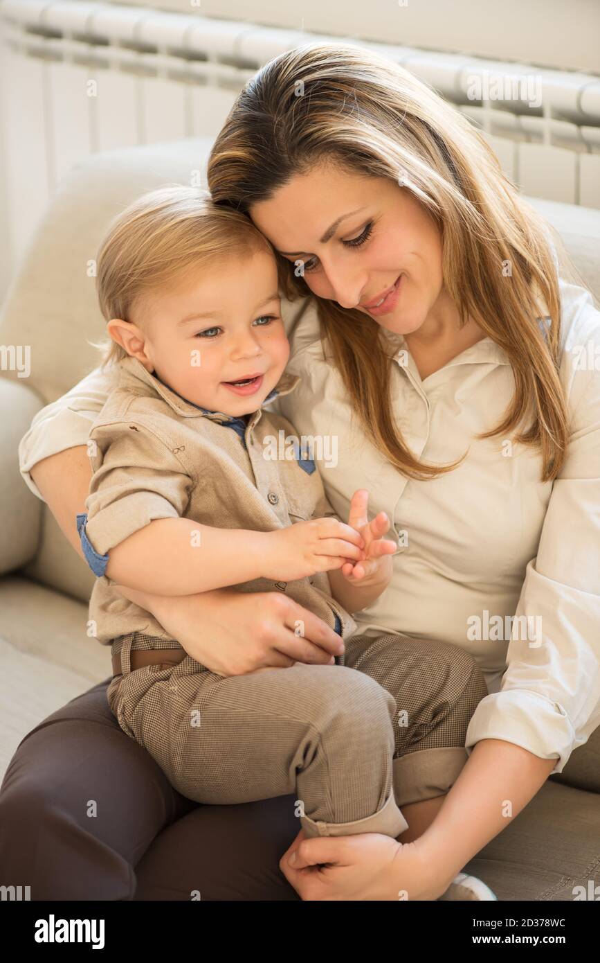Porträt von schönen Mutter und kleinen Sohn sitzen in ihrem Schoß ...