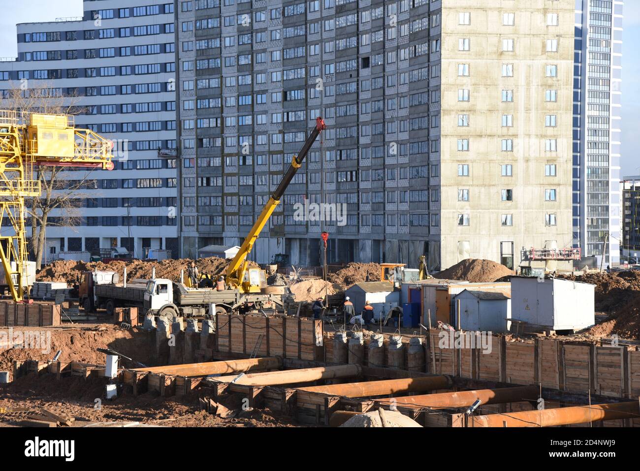 Mobile Autokrane arbeiten auf der Baustelle. Graben einer Grube für den ...