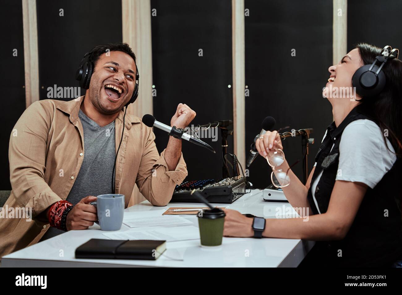 Portait von zwei Radio-Moderatoren, Mann und Frau lachen, während sie ...