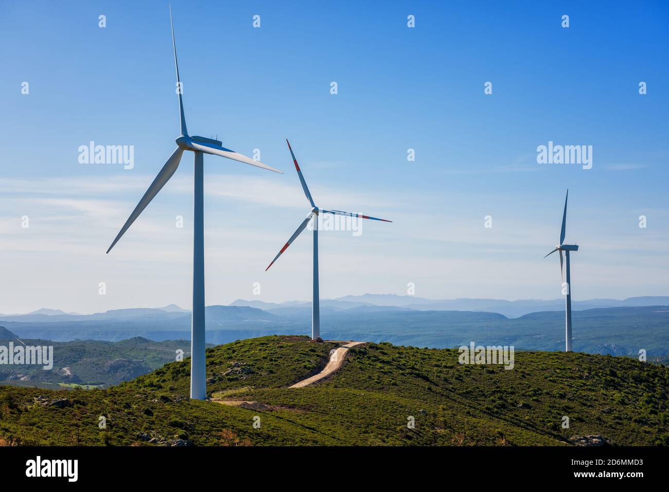 Windturbinen an einem wunderschönen blauen Himmel in einem Bergwindpark ...