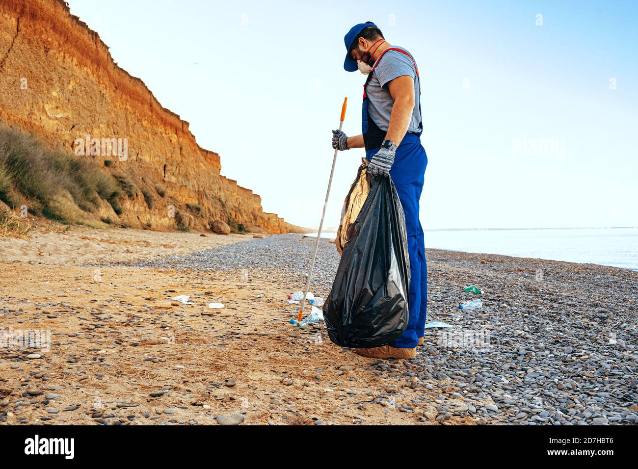 Mann sammeln freiwillig Müll am Strand mit einer Reichweite ...