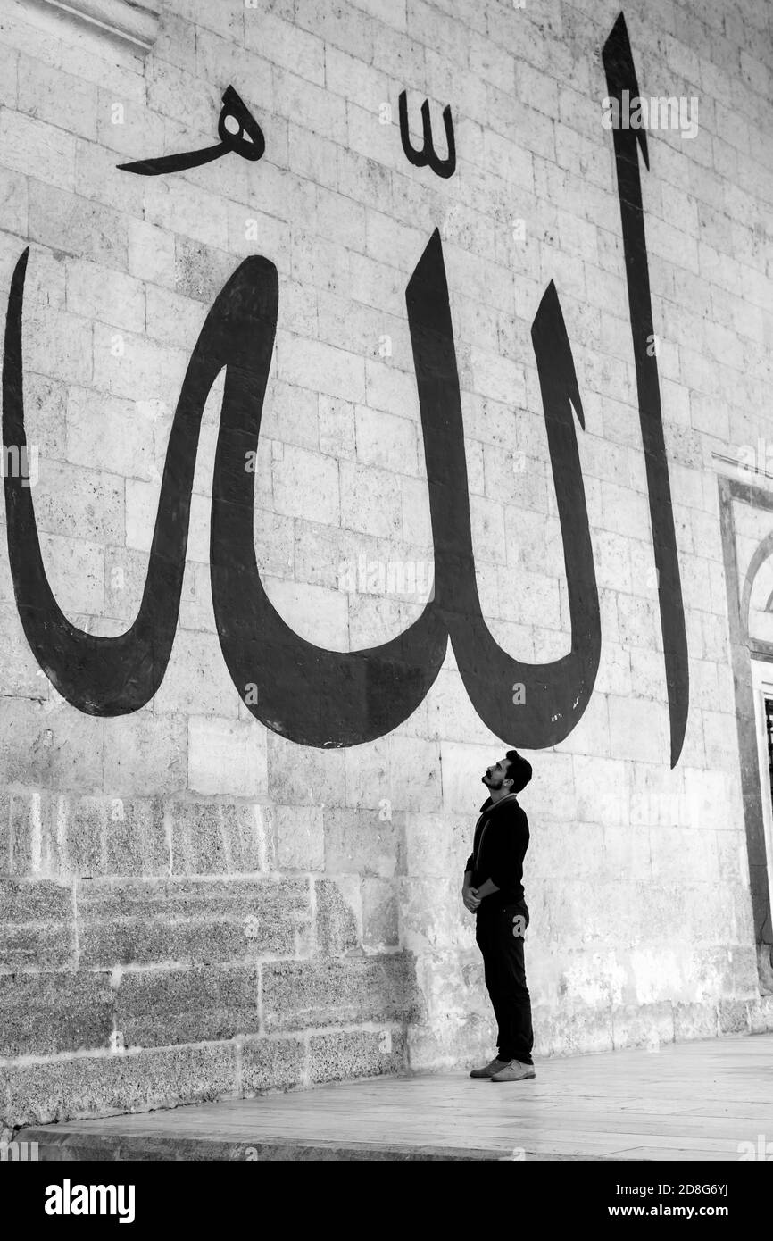 Junger Mann starrte auf die arabische Kalligraphie bedeutet "Allah-Gott ...