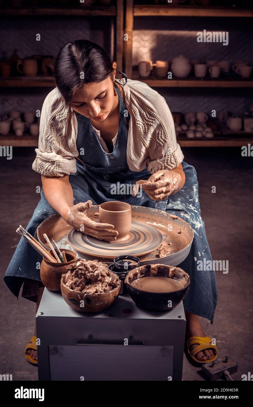 Der Töpfer arbeitet in der Werkstatt. Hände und ein Töpferrad ...