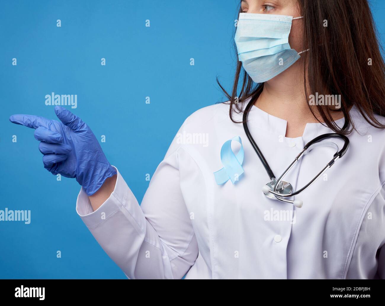 Ärztin in einer sterilen Einweg-Maske und einem weißen Mantel steht auf ...