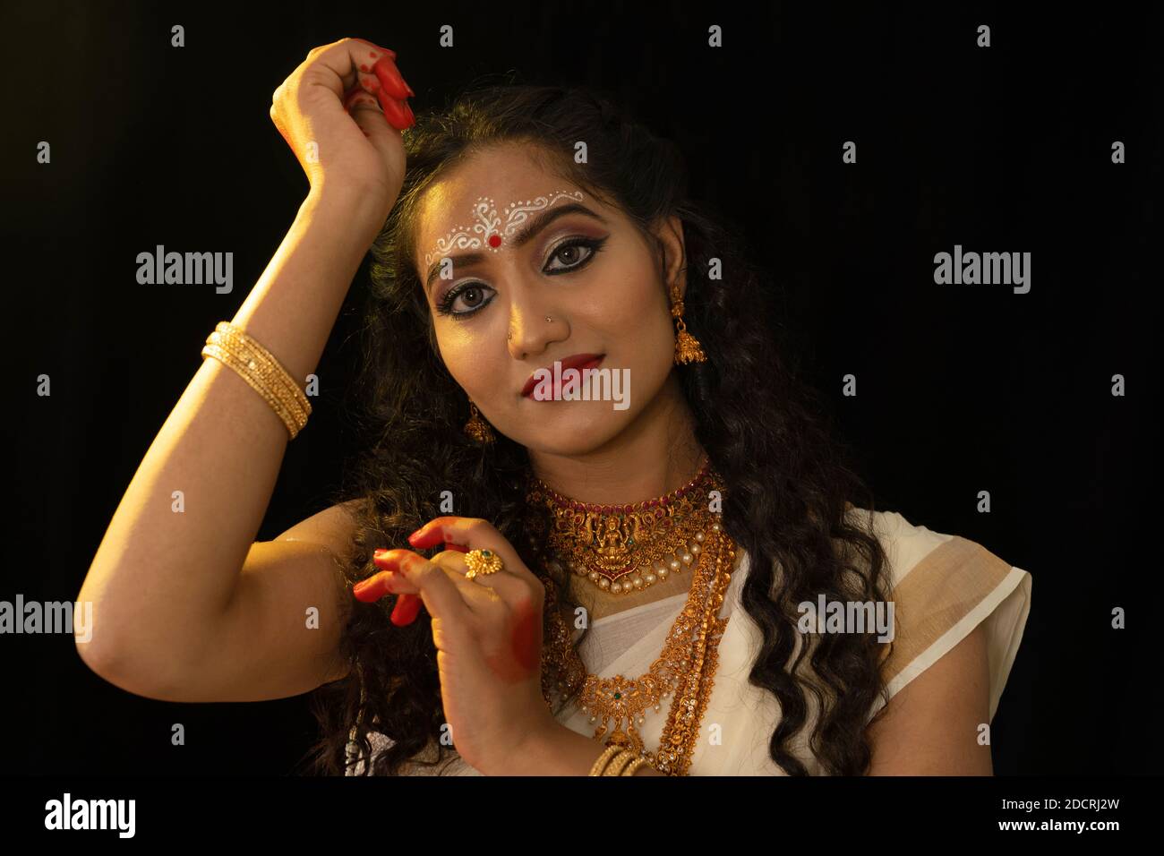 Indische Frau in weißem Saree, rote Bindi auf der Stirn und lange ...