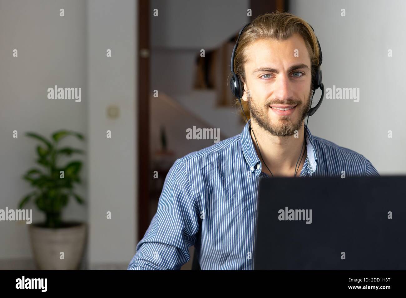 Blonde Männer arbeiten von zu Hause aus mit Kopfhörern über Wireless ...