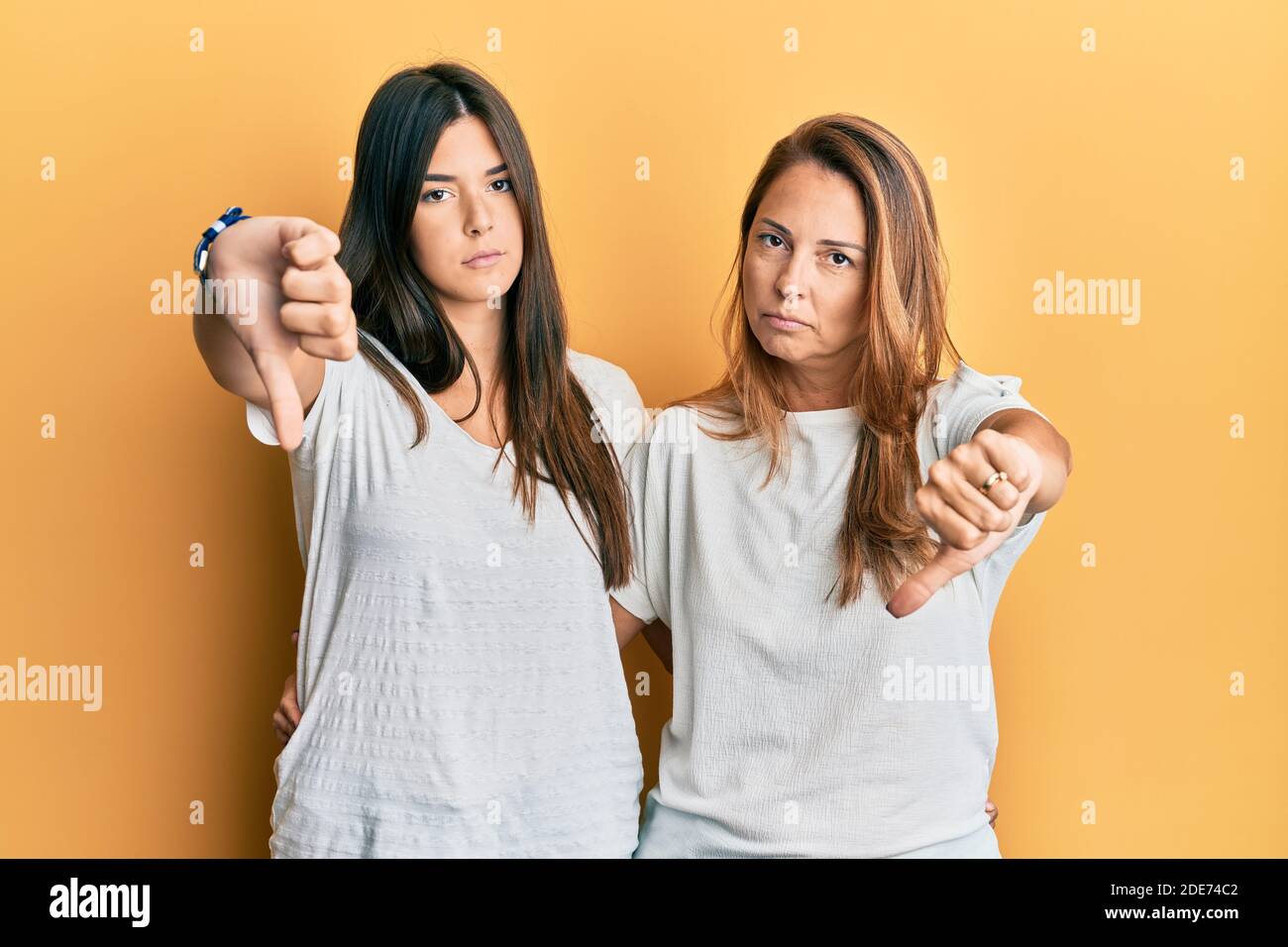 Hispanische Familie von Mutter und Tochter tragen beiläufige weiße T ... Hispanische Familie von Mutter und Tochter tragen beiläufige weiße T ...